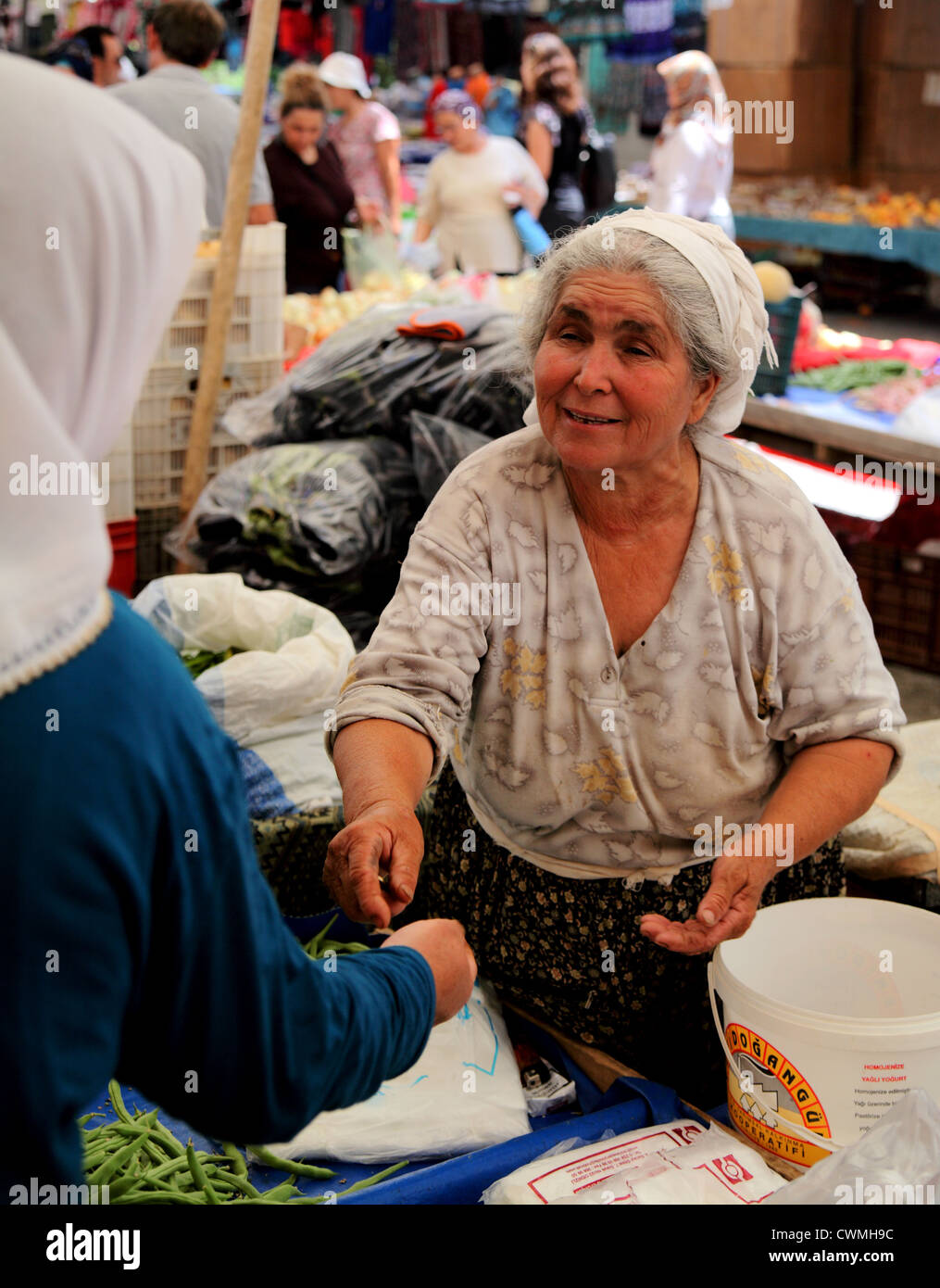Turkish woman stallkeeper gives change to female customer in market ...