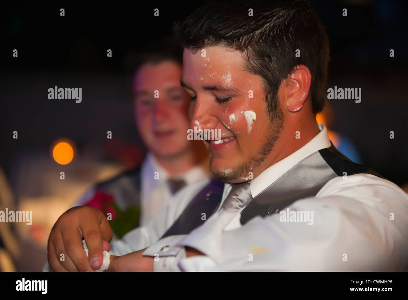 Bride and groom smearing each others faces with icing during a ...