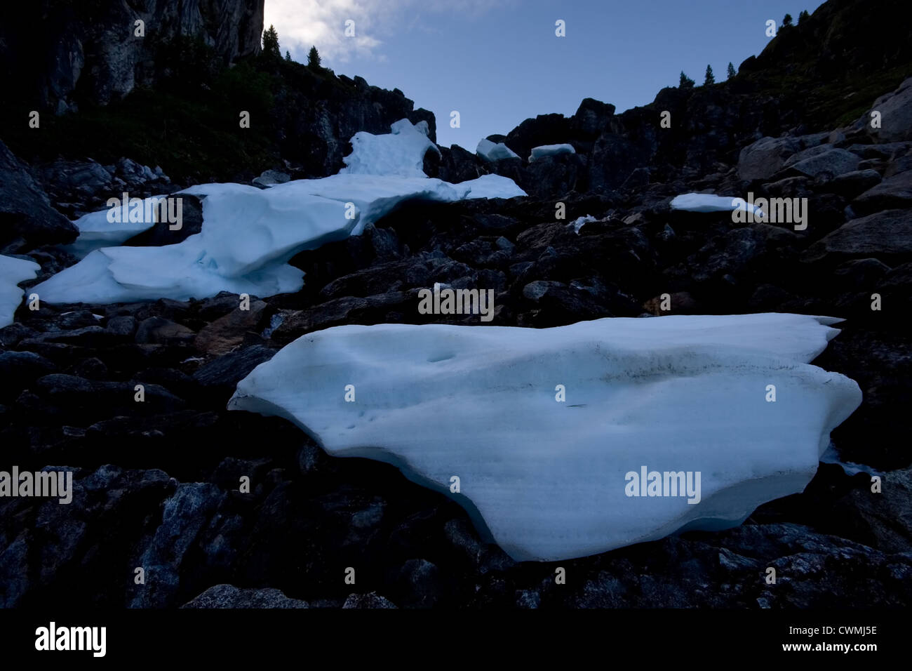 Blue wavy ice shape (glacier) against a valley in Sayan mountains. Wild ...