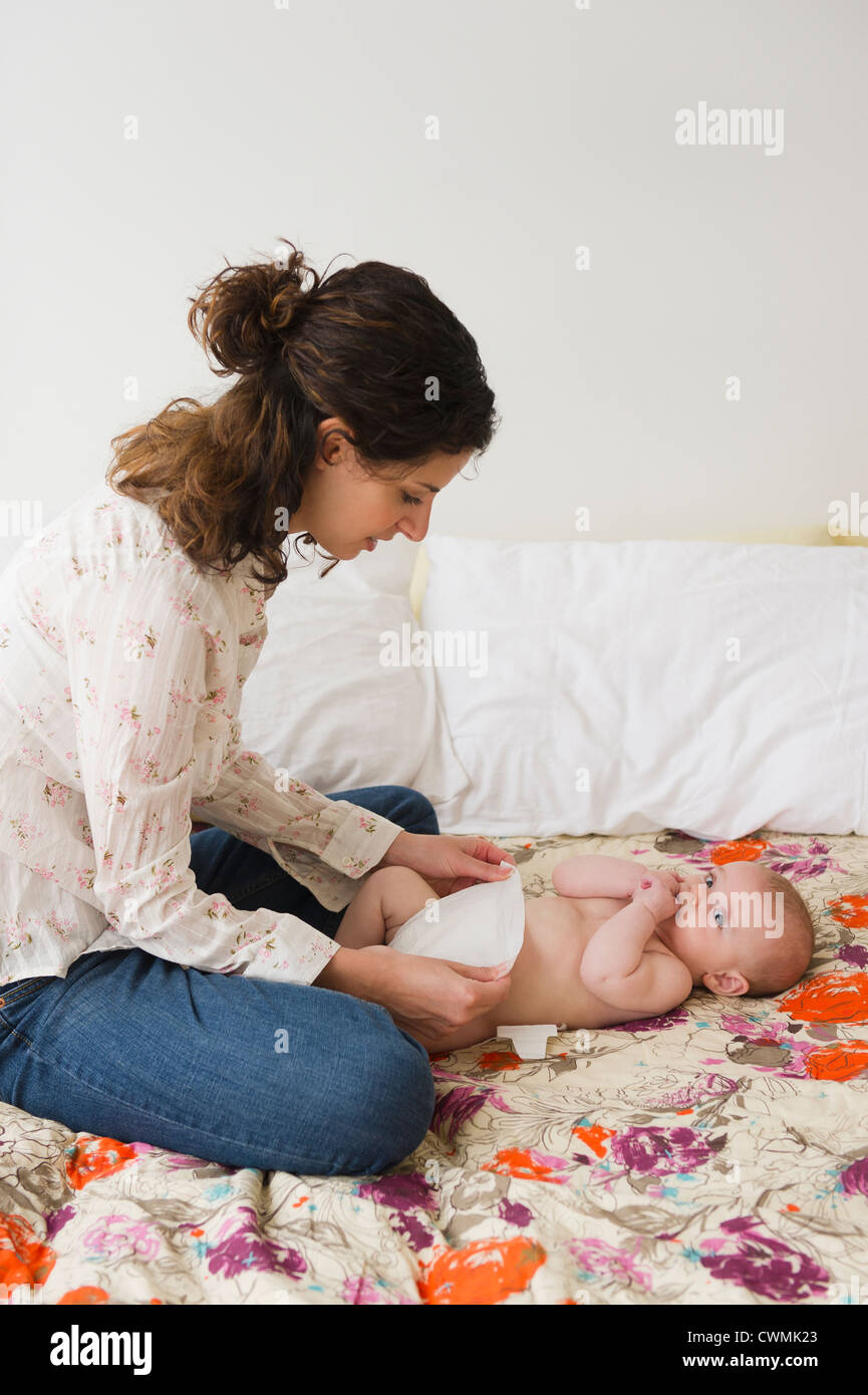 USA, New Jersey, Jersey City, Mother changing baby boy (2-5 months ...