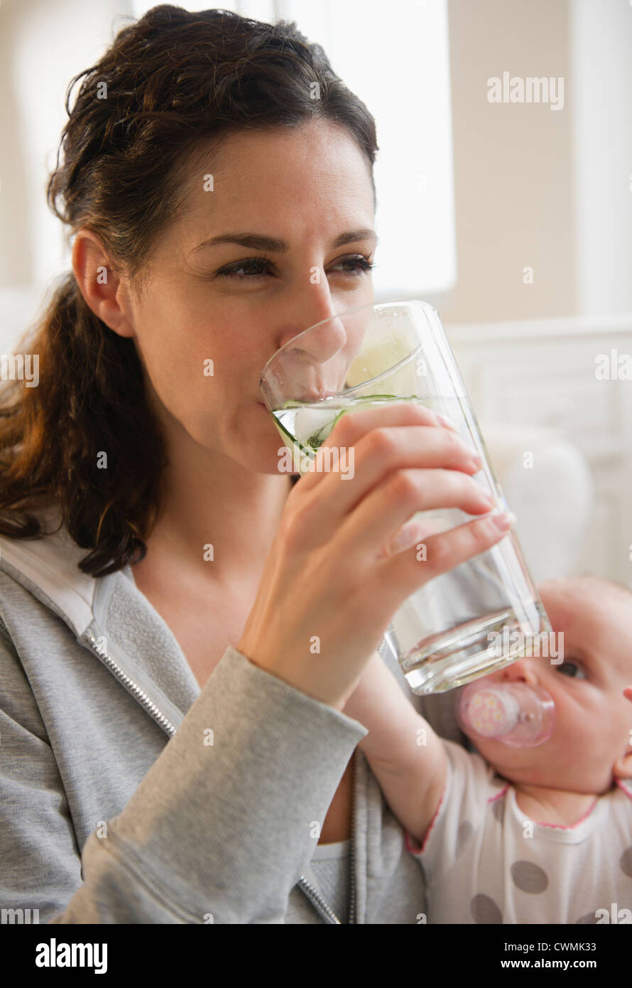 USA, New Jersey, Jersey City, Mother drinking water with baby boy (2-5 ...