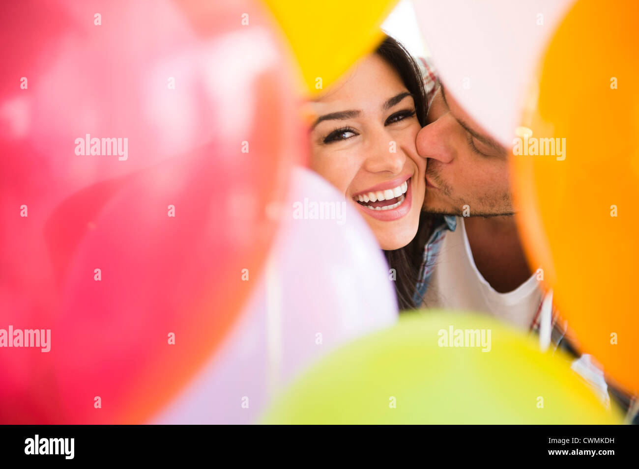 USA, New Jersey, Jersey City, Man kissing woman behind colorful ...