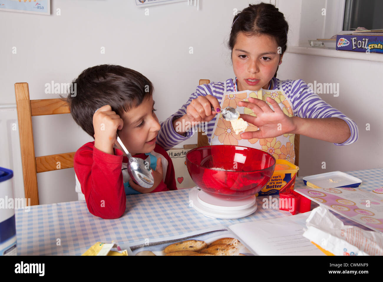Child adding ingredients to make cakes Stock Photo - Alamy