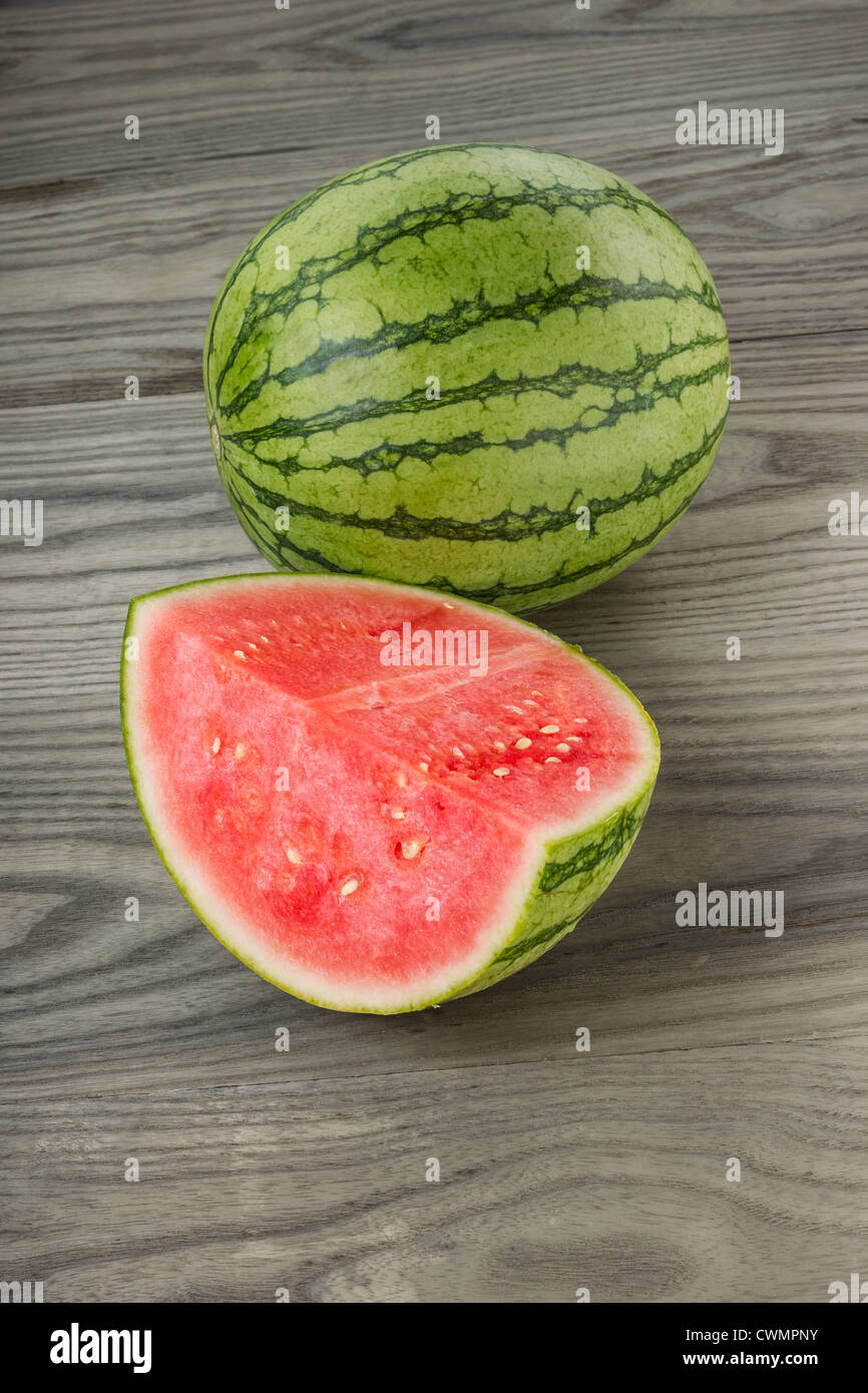 Whole and part water melon on natural aging white ash wood background ...
