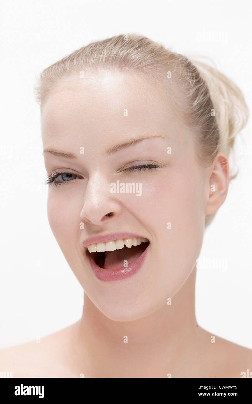Portrait of young woman laughing and making eye Stock Photo - Alamy