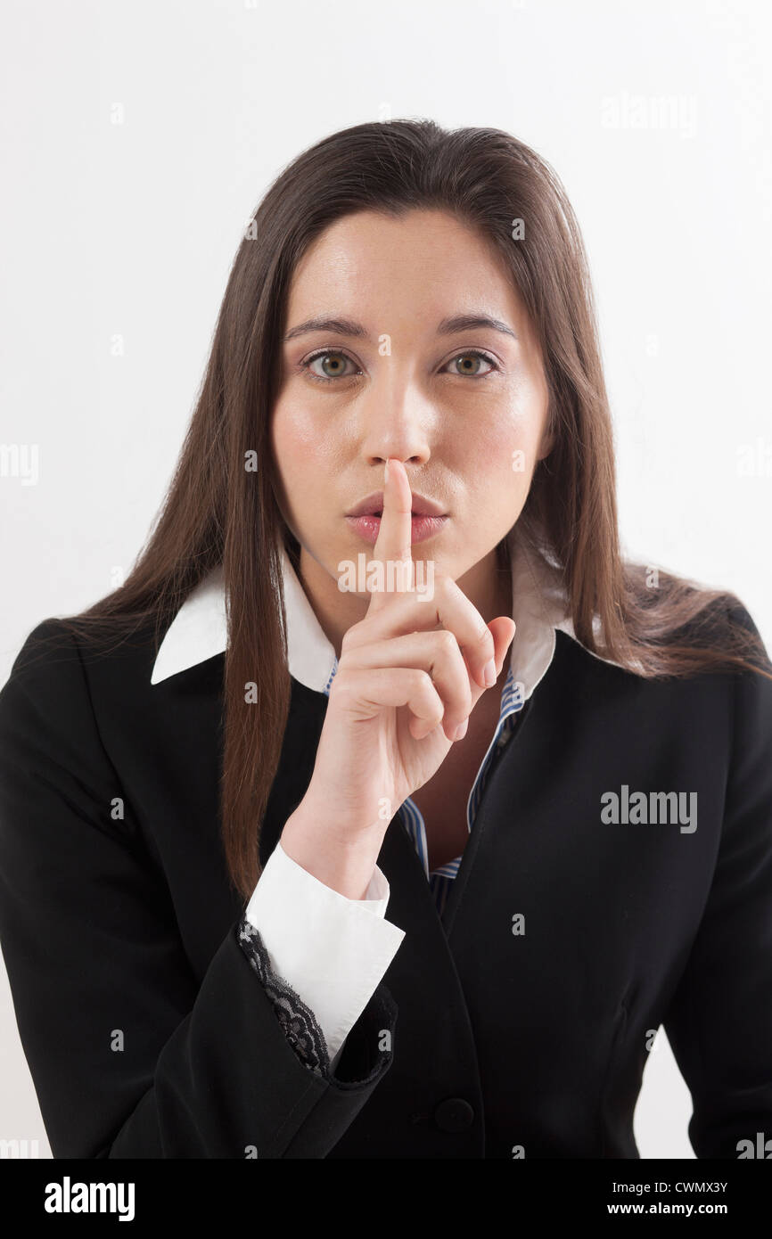 Young woman with finger on her lips, studio shot Stock Photo - Alamy