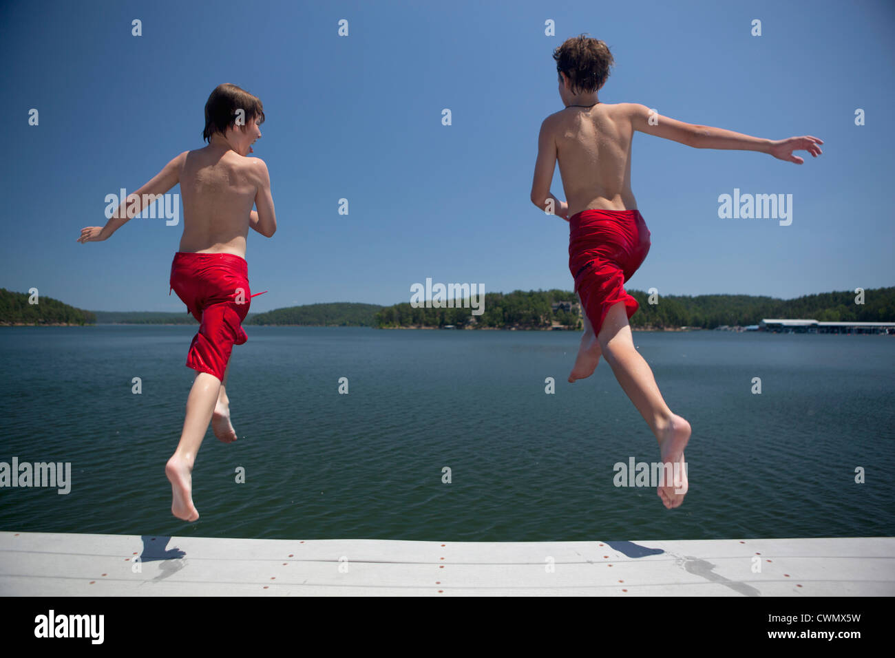 USA, Arkansas, Murfreesboro, Two brothers (8-9, 12-13) jumping into ...