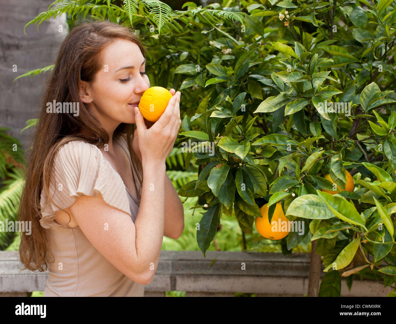 Woman smelling orange fruit hi-res stock photography and images - Alamy