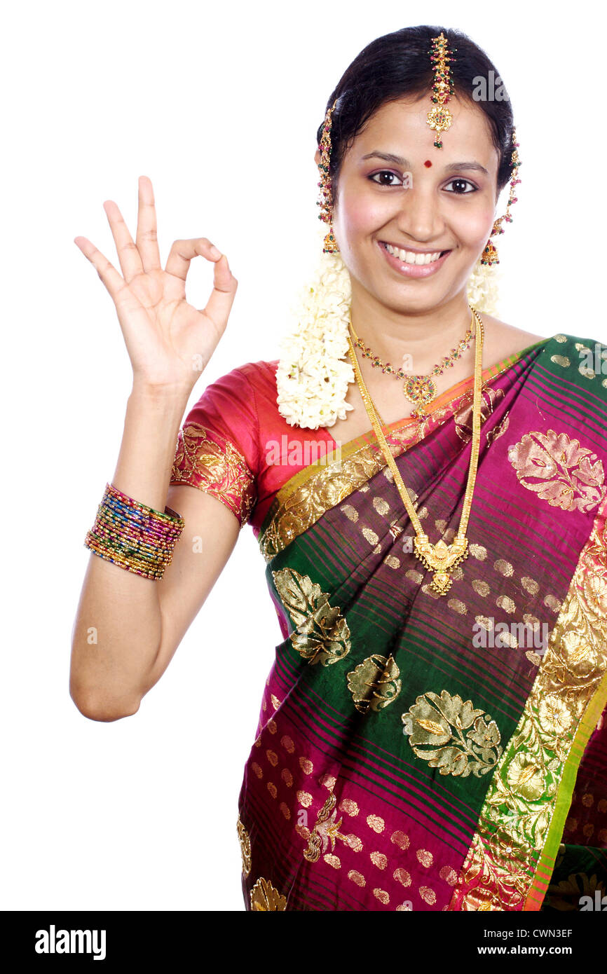 Traditional Indian young woman showing OK sign against white background ...