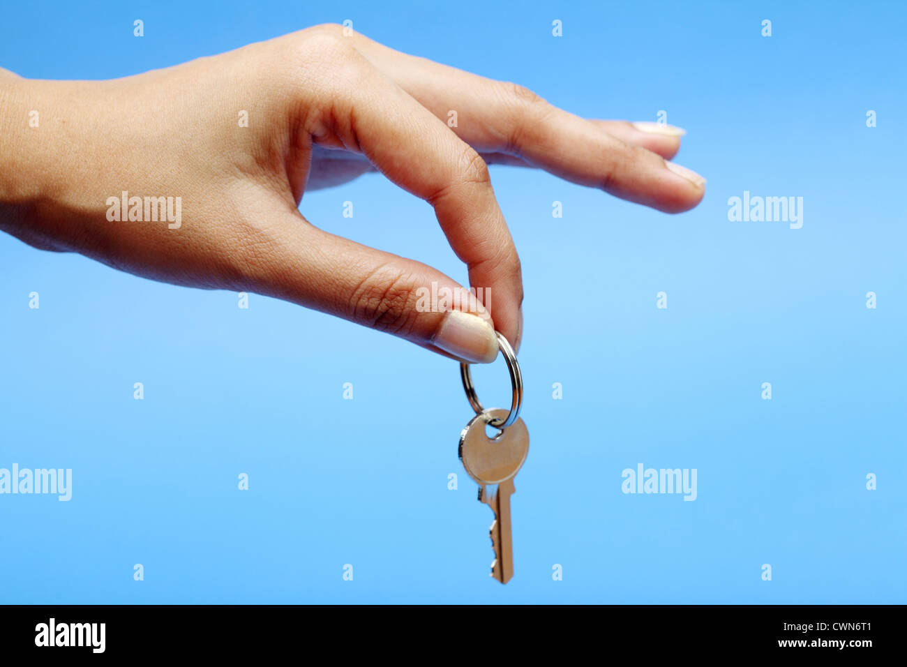 Key in hand isolated on blue background Stock Photo - Alamy