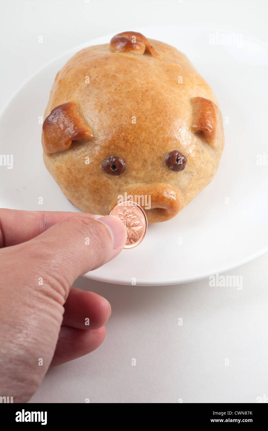 Piggy bank on a dish and a Canadian penny Stock Photo - Alamy
