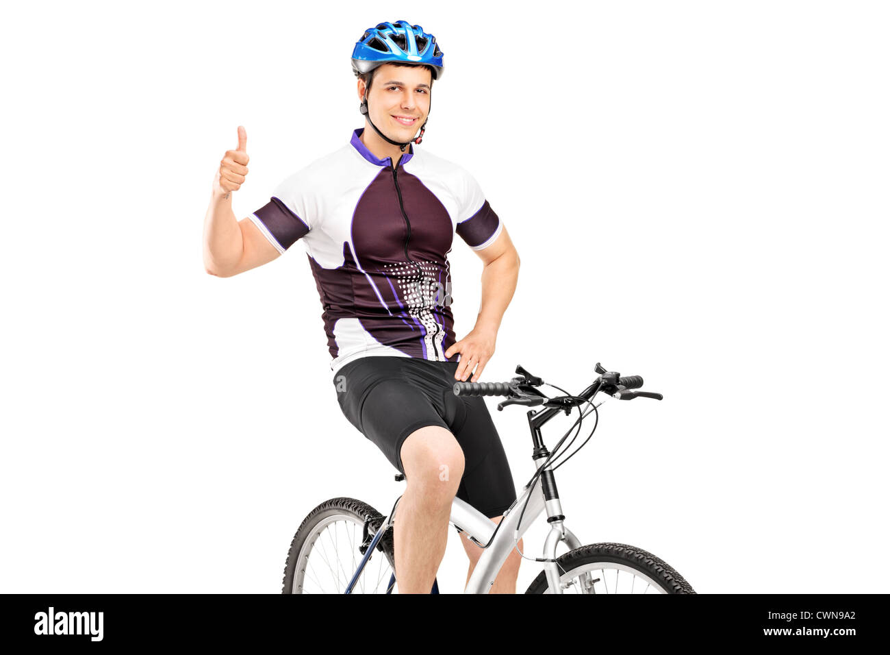 A smiling bicyclist posing on a bicycle and giving a thumb up isolated ...