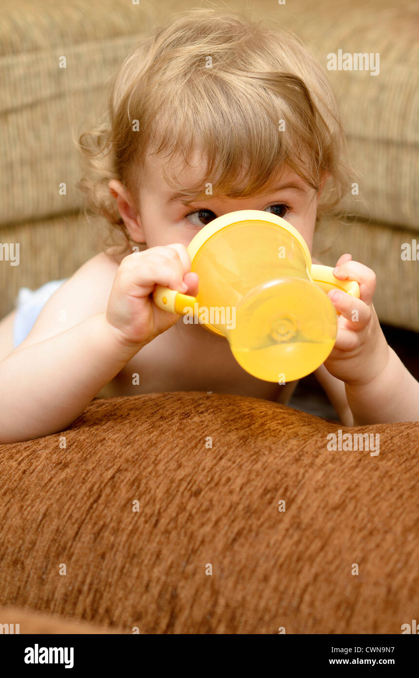 Little girl drinking from beaker Stock Photo - Alamy