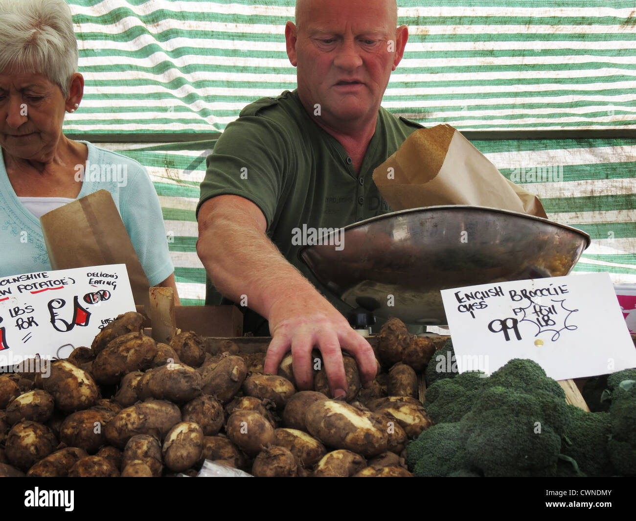 Man selling potatoes on market stall Stock Photo - Alamy