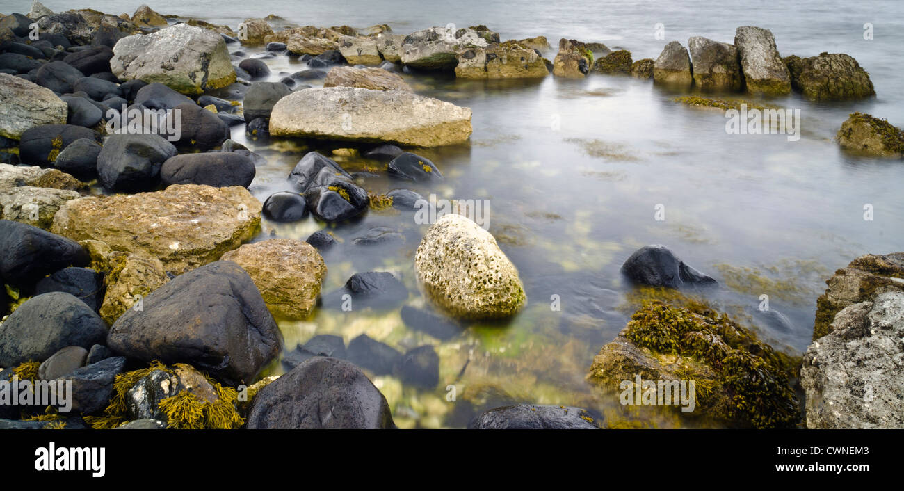 A seaside rock pool on the shores of Blackhead Path, County Antrim ...