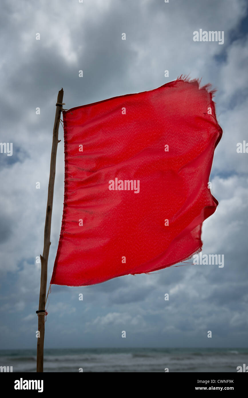 Red warning flag at a beach with storm clouds on background Stock Photo ...