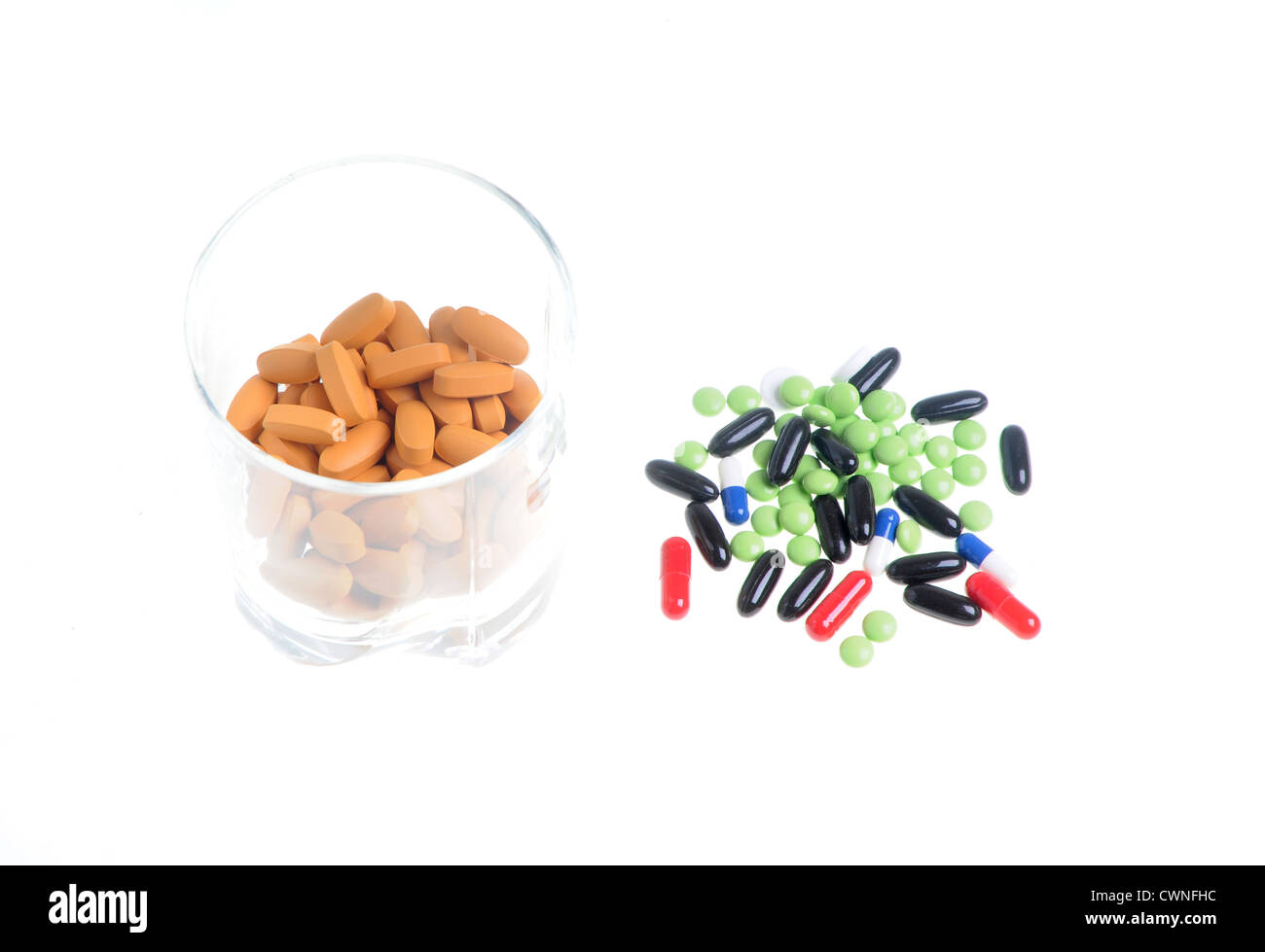 coloured pills and orange tablets in glass Stock Photo - Alamy