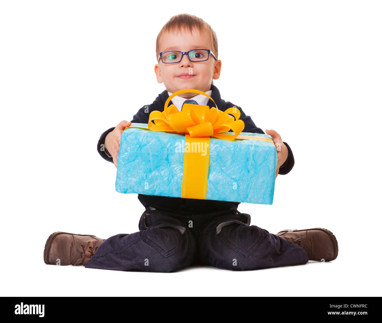 Small sitting boy in spectacles holds a big blue present on white ...