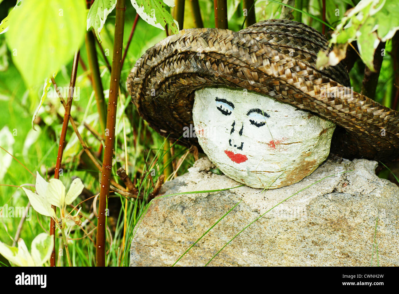 Original homemade garden decoration with round painted rock as a woman ...