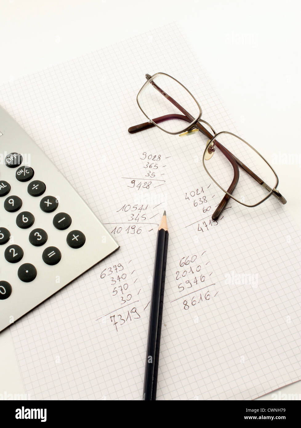 Addition of a written paper, a calculator and pen Stock Photo - Alamy