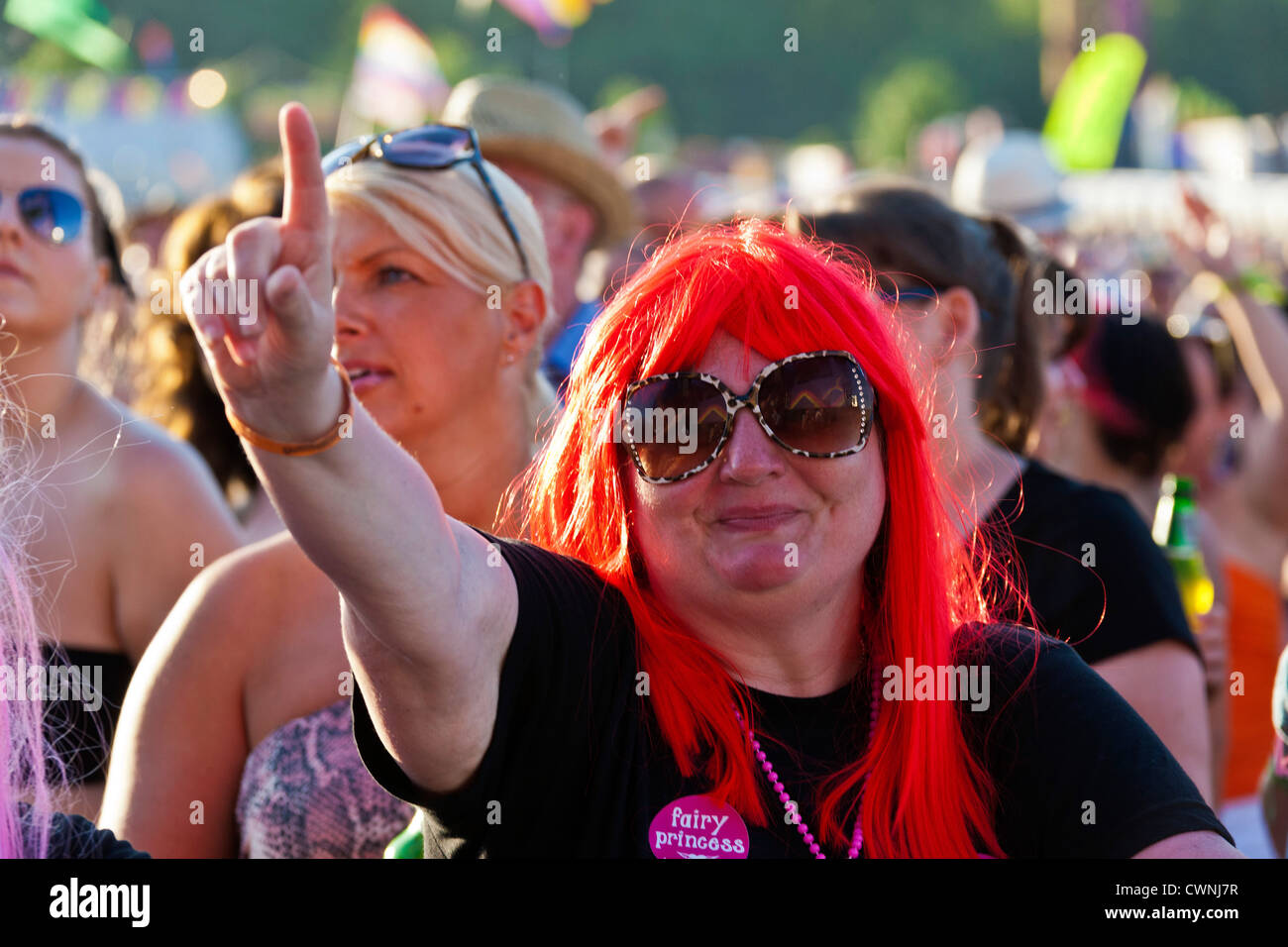 Festival goer in the crowd with red hair in front of the stage at the ...