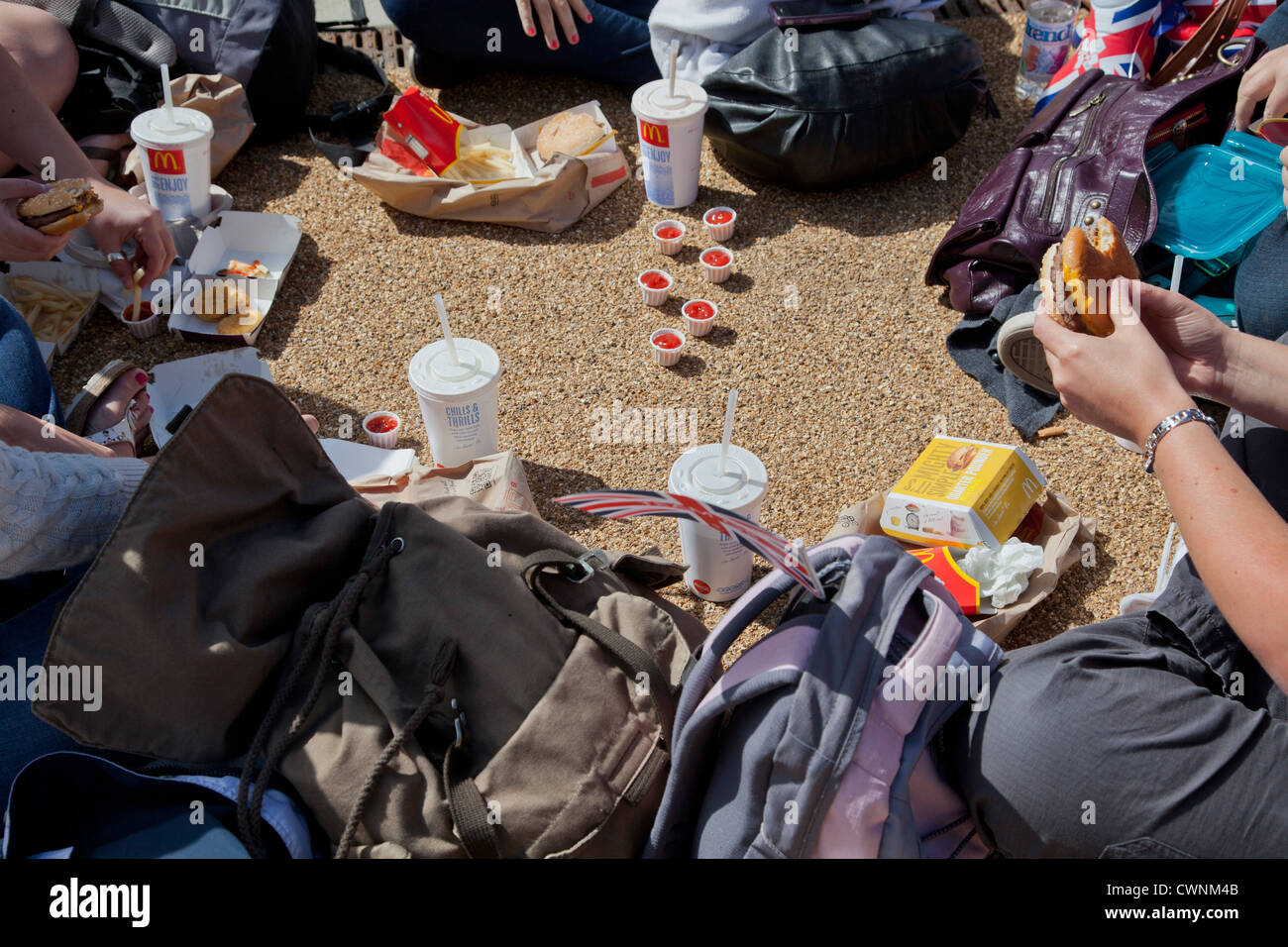 Spectators eat outside Mac Donald's restaurant at the London 2012 ...