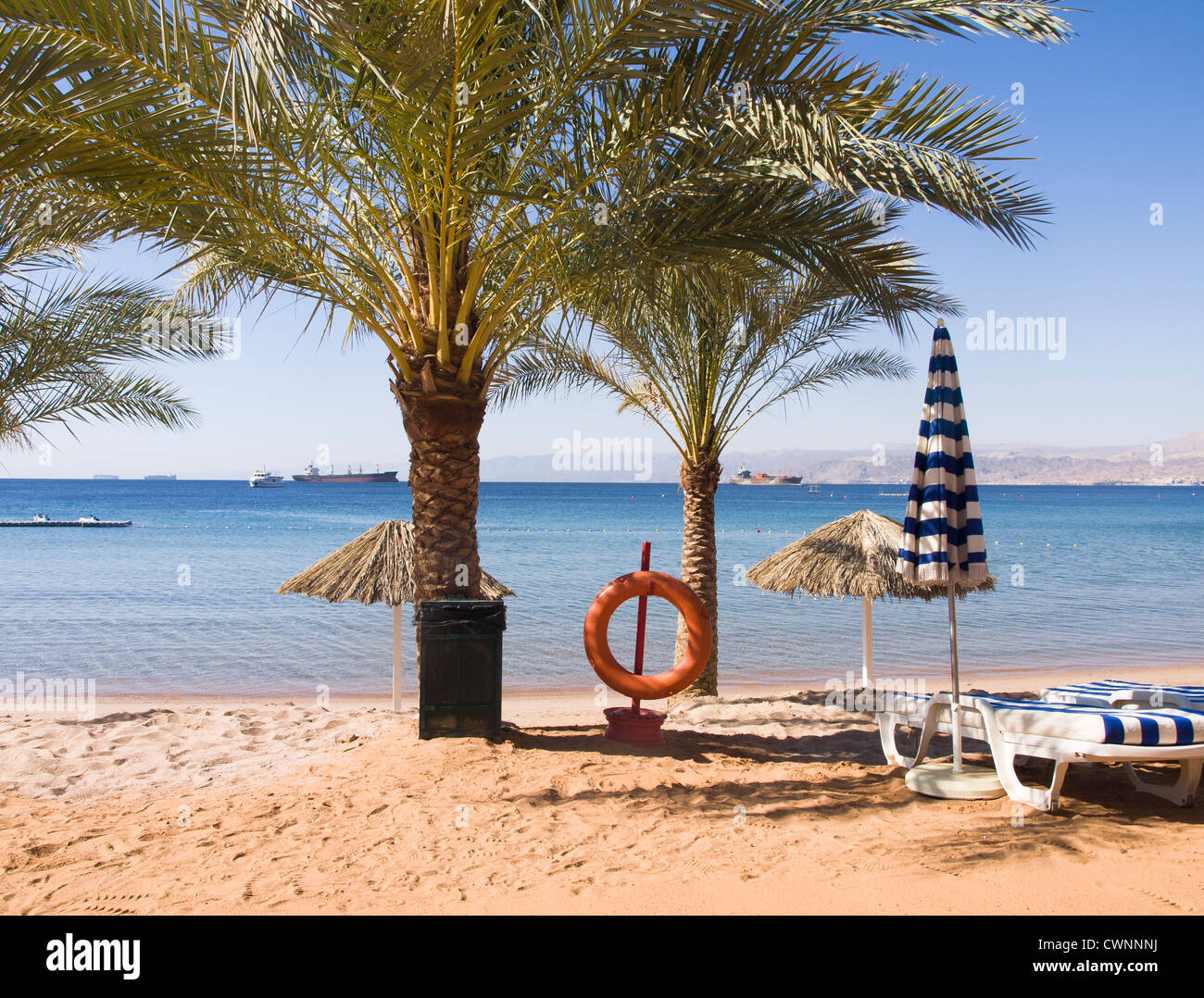 Beach on the Red Sea in Aqaba Jordan, complete with parasol sun-bed ...