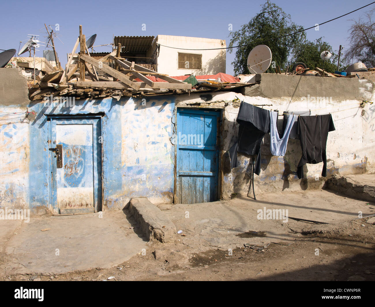 Basic house in old Aqaba Jordan in blue and white with clothes on the ...