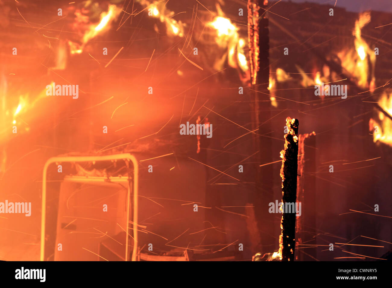 House interior destroyed by intense fire. Flames, smoke and sparks ...