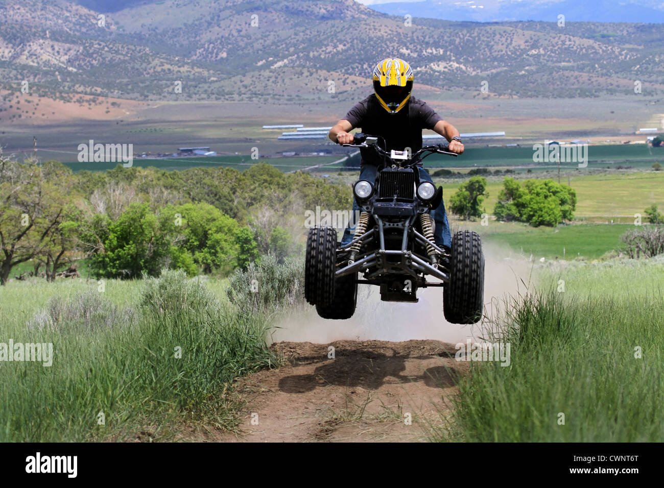 Motorcycle ATV ride on rough dirt track by man.Jumps over earth ramps ...