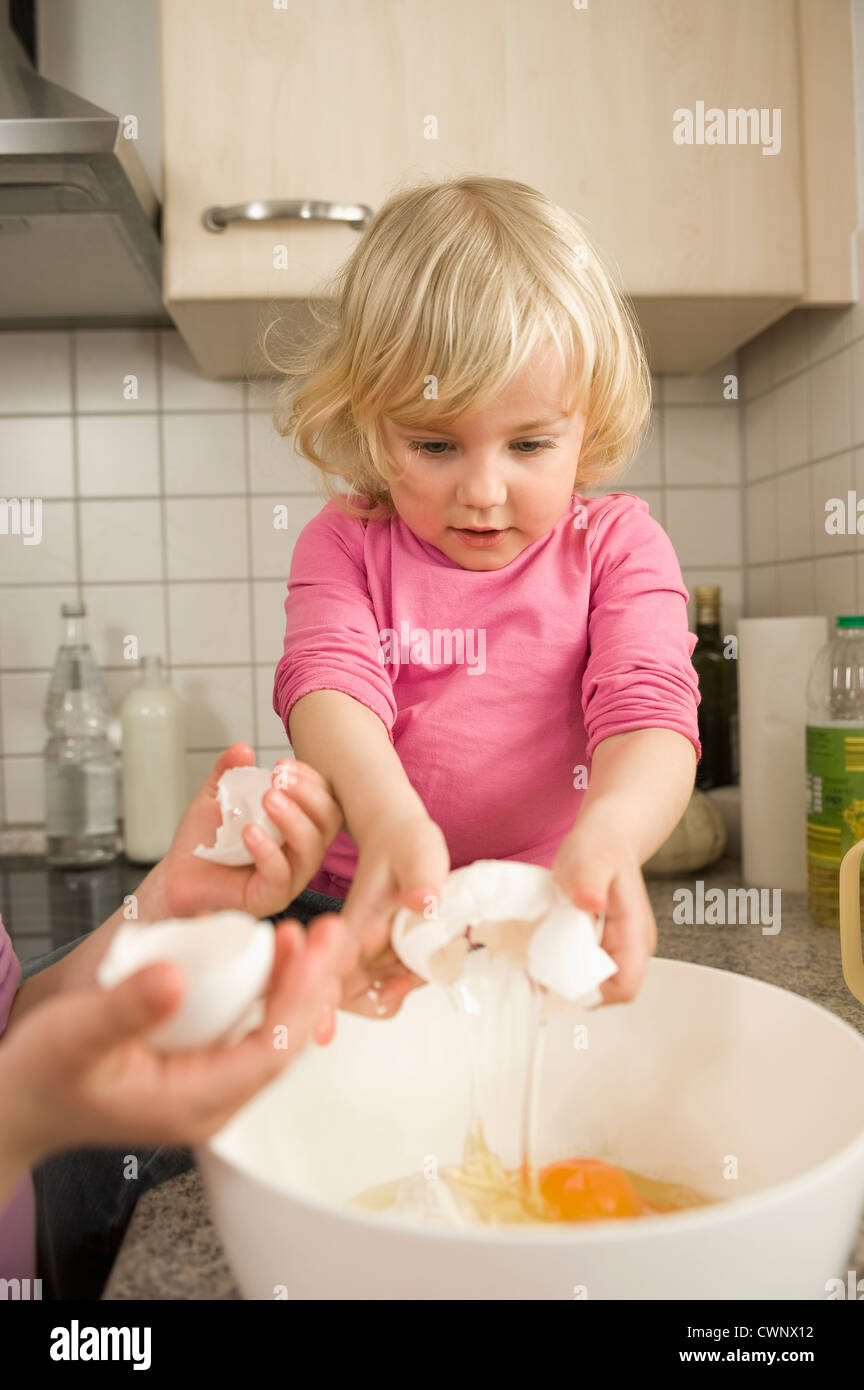 Girls pouring egg yolk in mixing bowl Stock Photo - Alamy