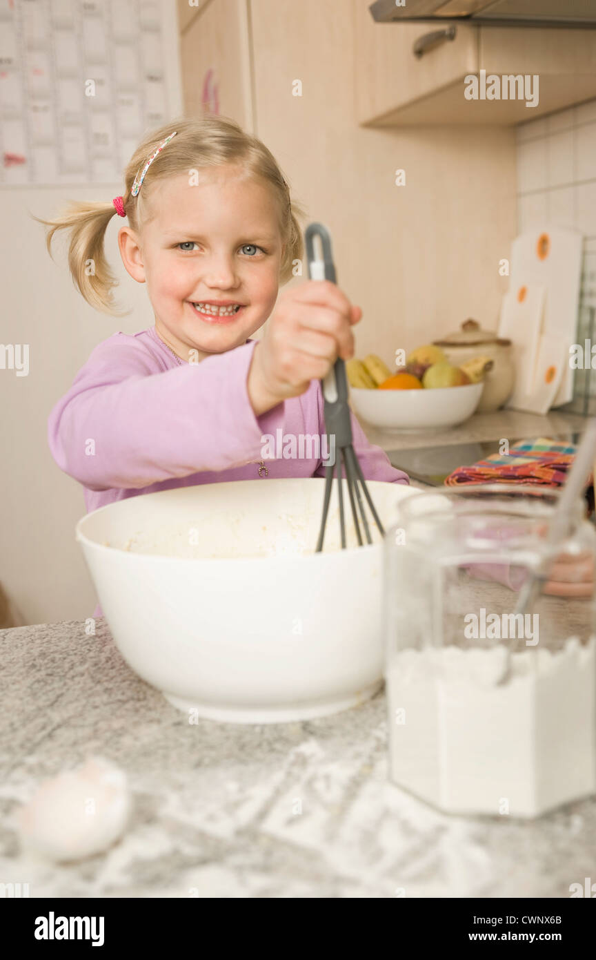 Girl mixing batter in bowl, smiling Stock Photo - Alamy