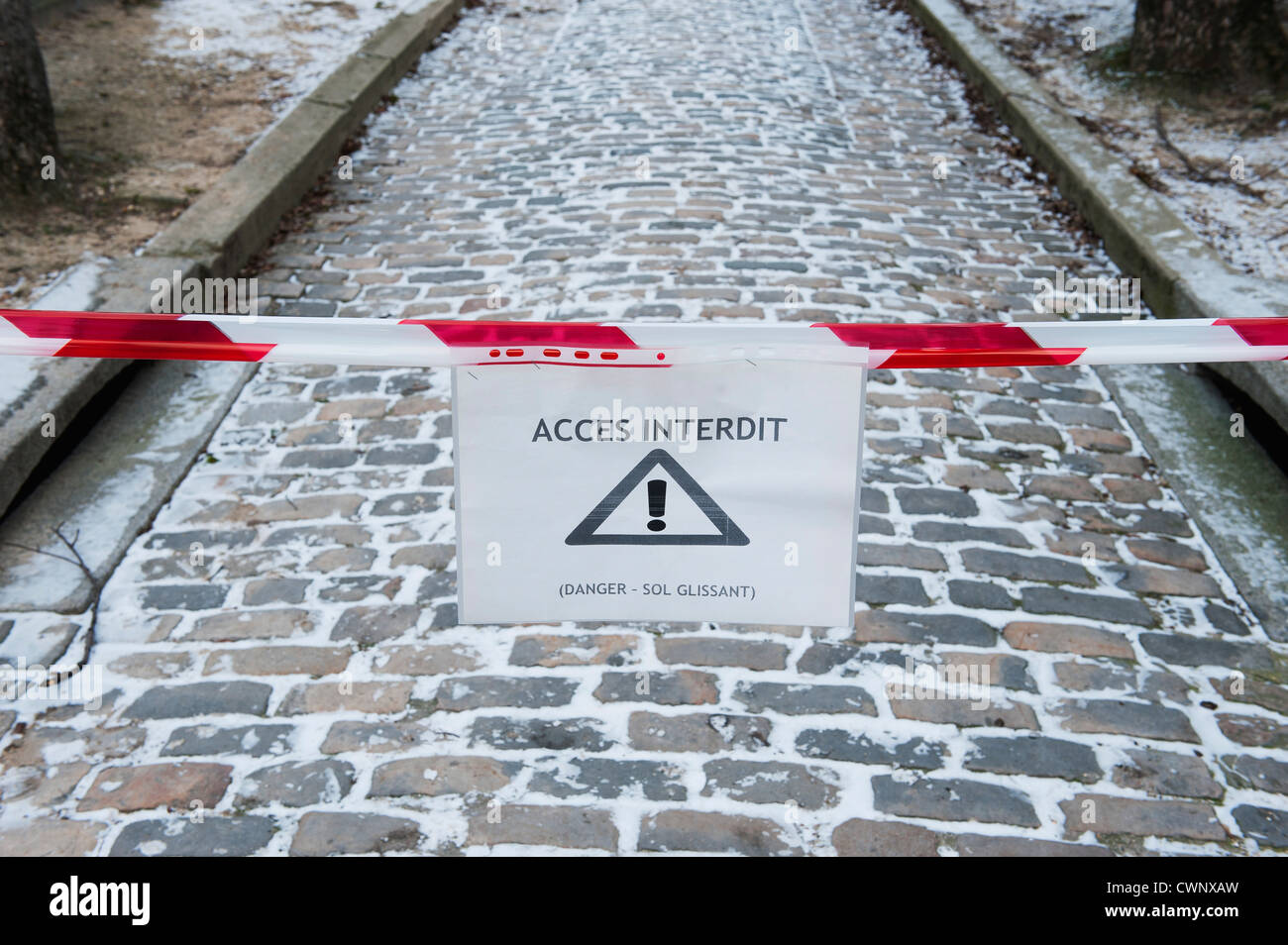 Sign warning pedestrians of slippery walkway in winter Stock Photo - Alamy