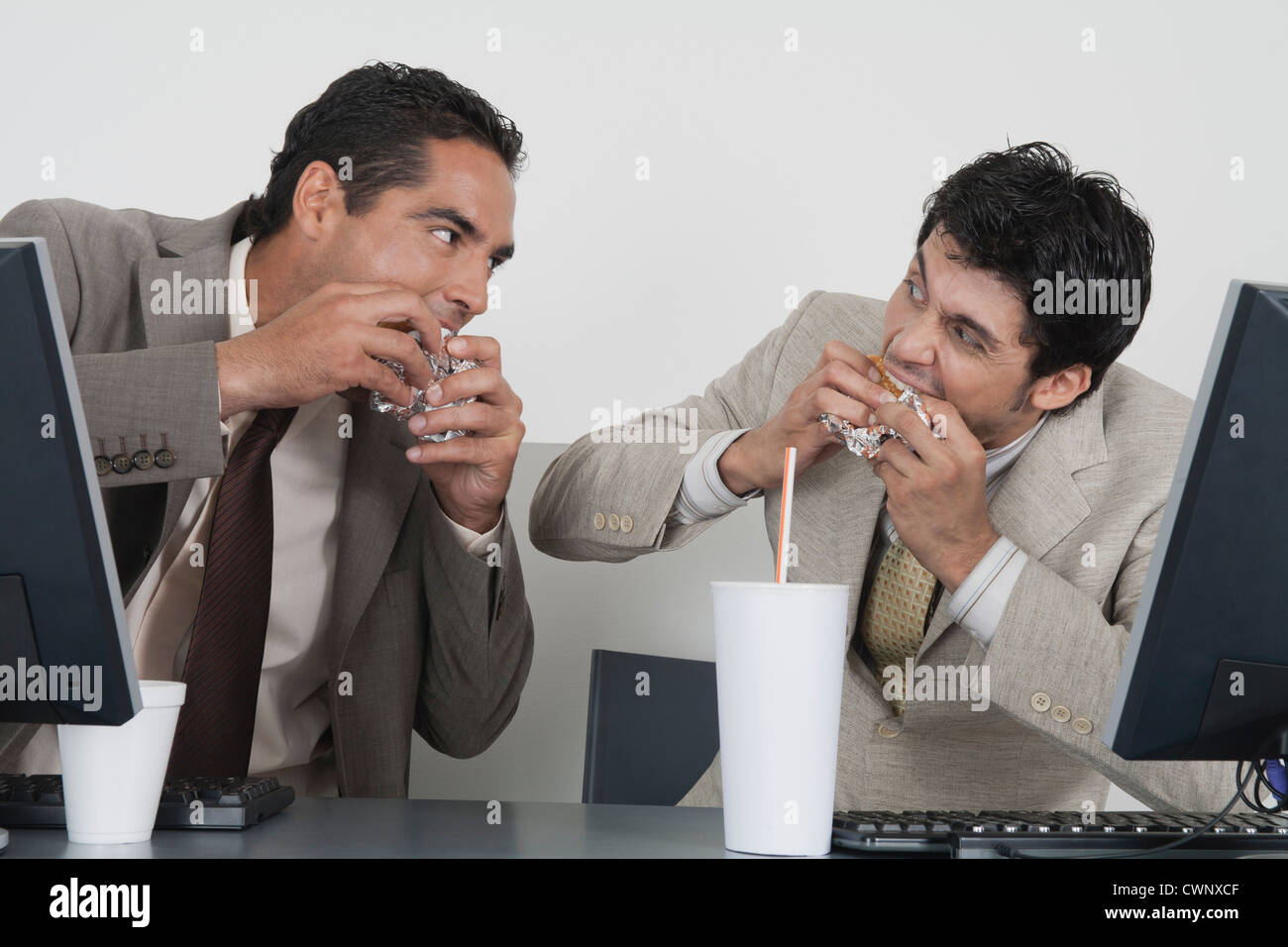 Businessmen eating fast food at desk in office Stock Photo - Alamy