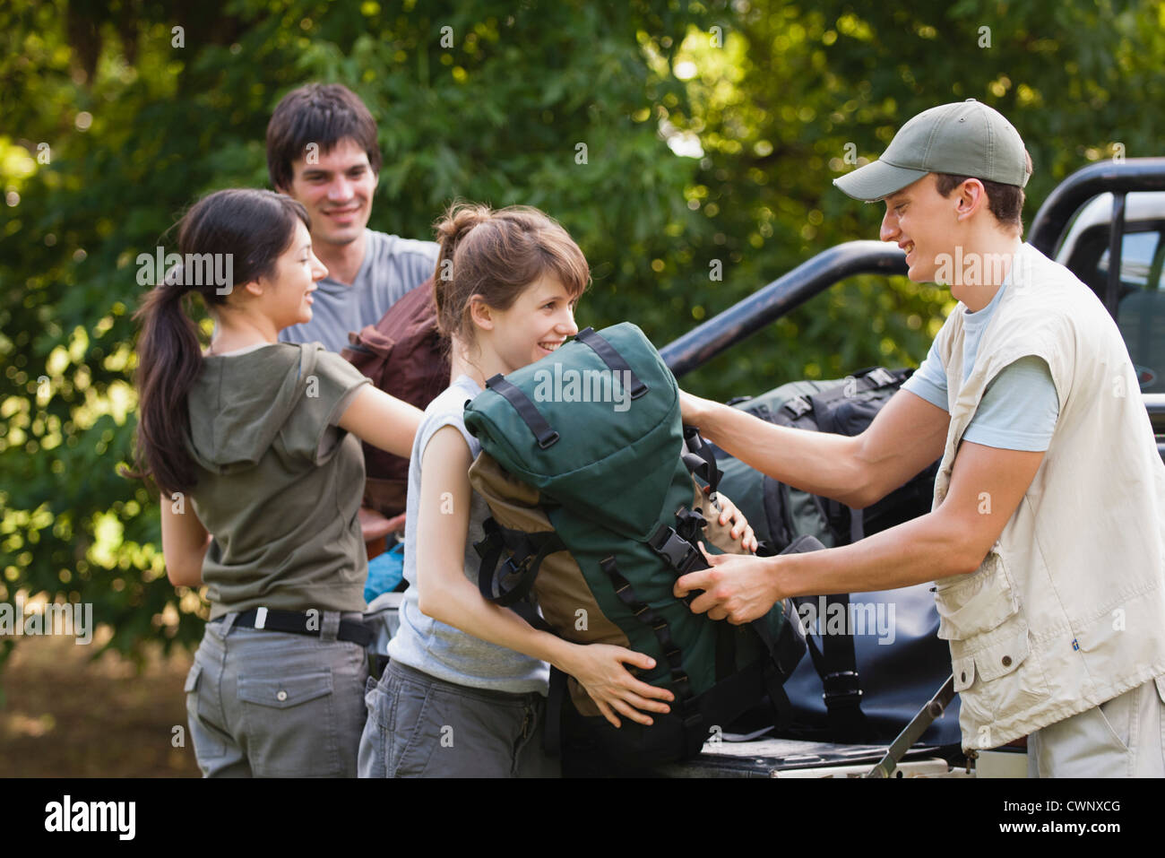 Young campers unloading backpacks from back of pick-up trucks Stock ...