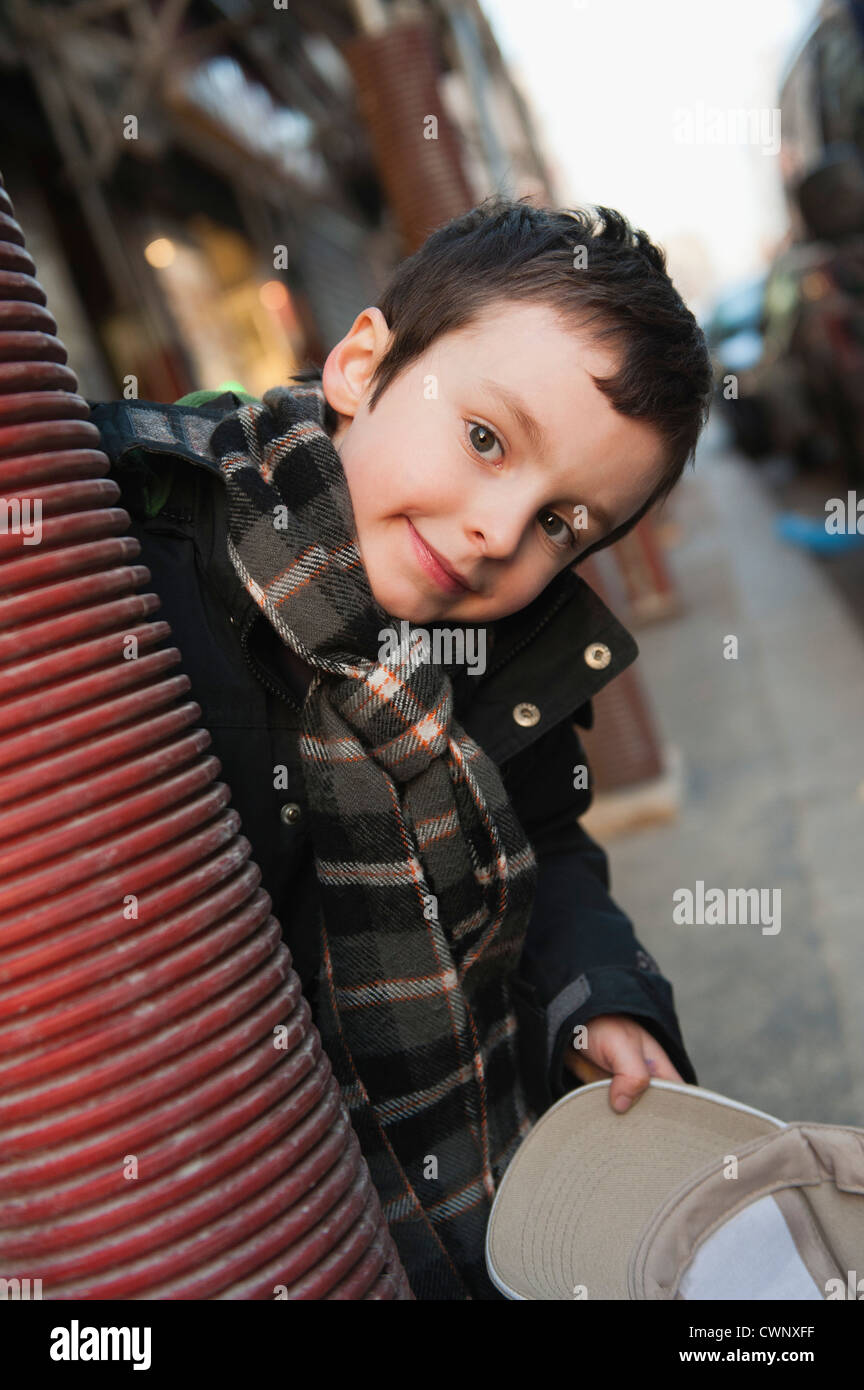Boy peering around column at camera, portrait Stock Photo - Alamy