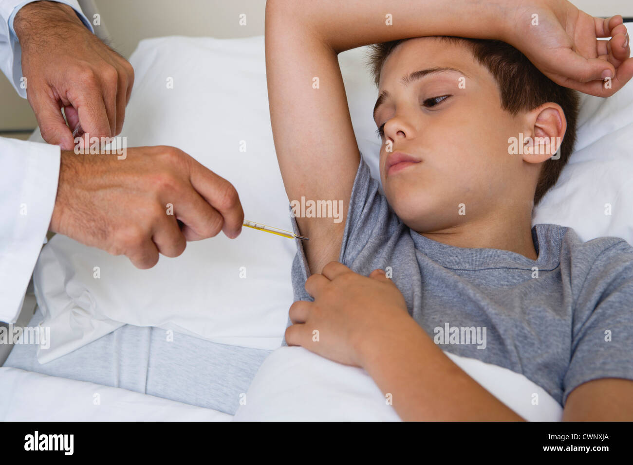 Doctor taking boy's temperature with thermometer, cropped Stock Photo ...