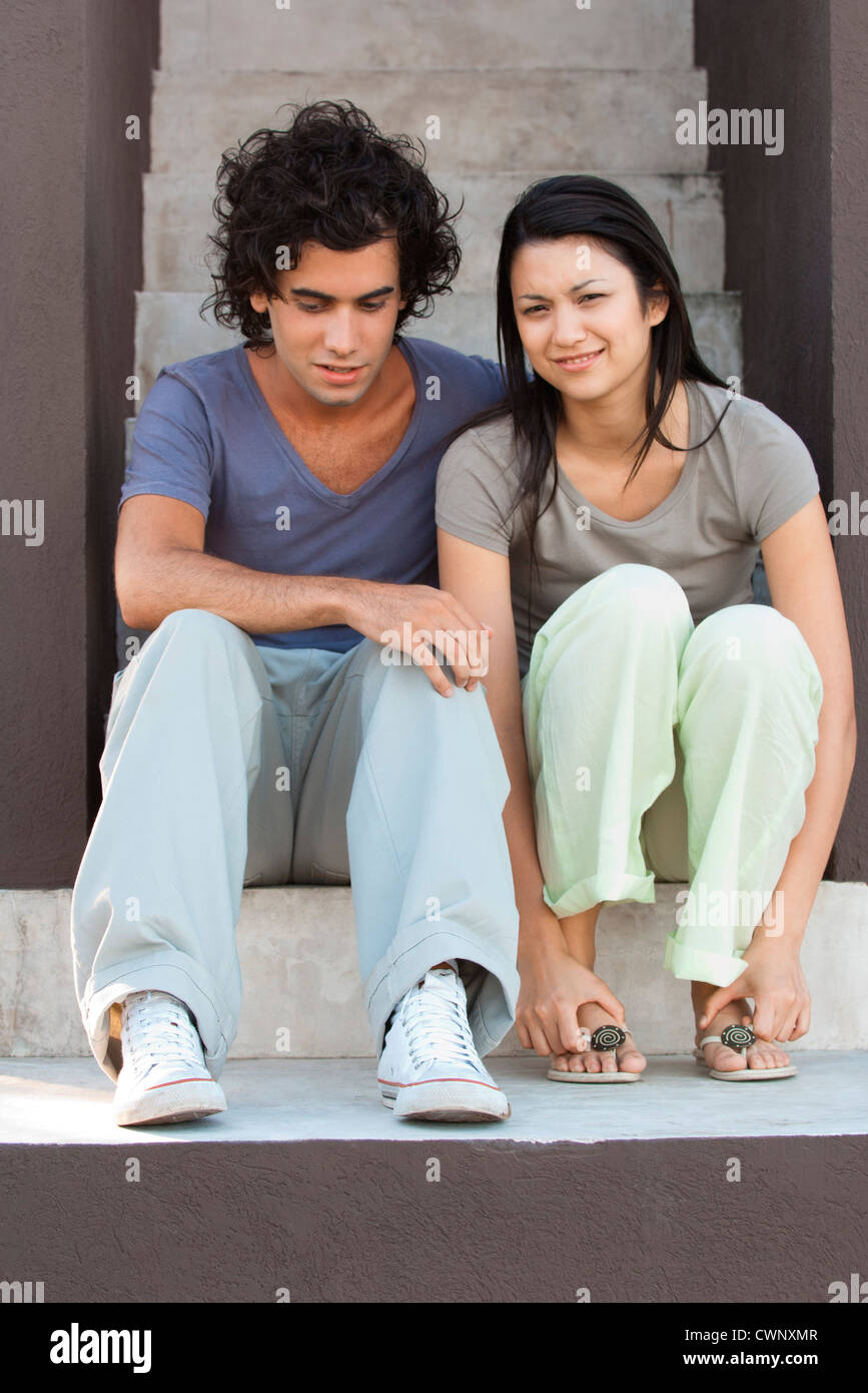 Young couple sitting together on steps Stock Photo - Alamy