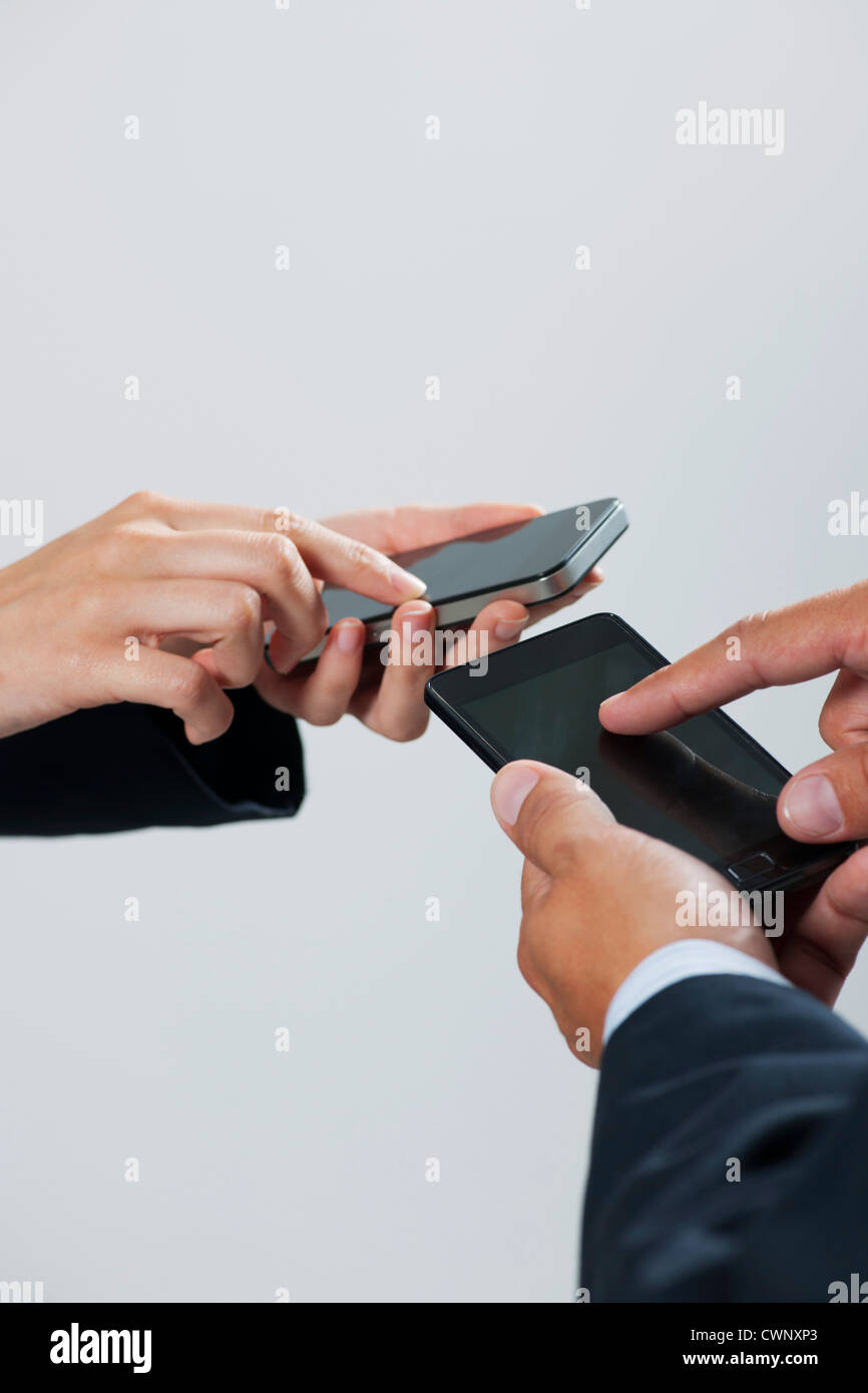Colleagues exchanging information with smartphones, cropped Stock Photo ...
