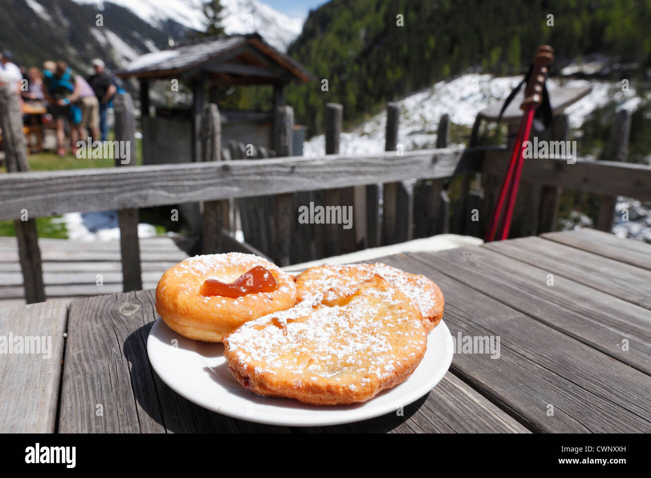 Austria, Styria, Gfolleralm, Donut in plate with people in background ...