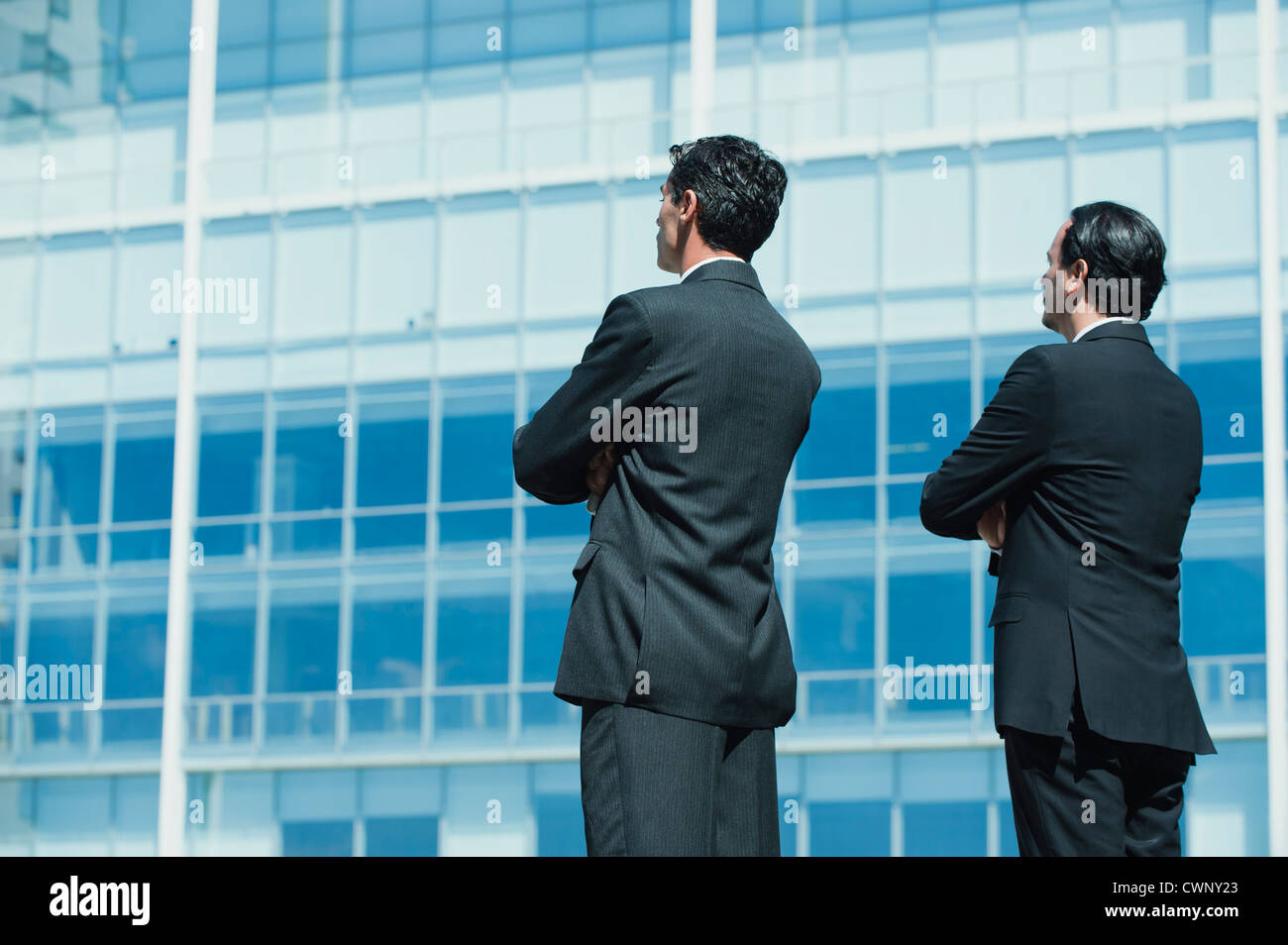 Executives standing by office building with arms folded Stock Photo - Alamy