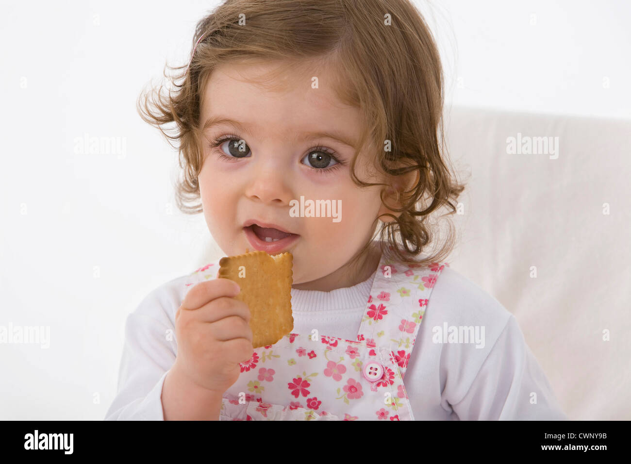 Baby girl eating cookie, close up Stock Photo - Alamy