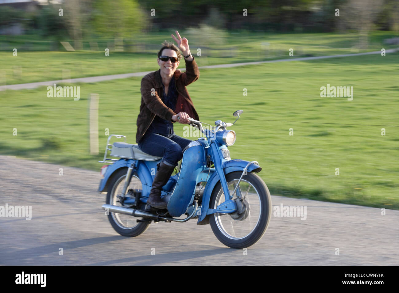 Germany, Bavaria, Mature woman riding old moped of 1960s, smiling Stock ...