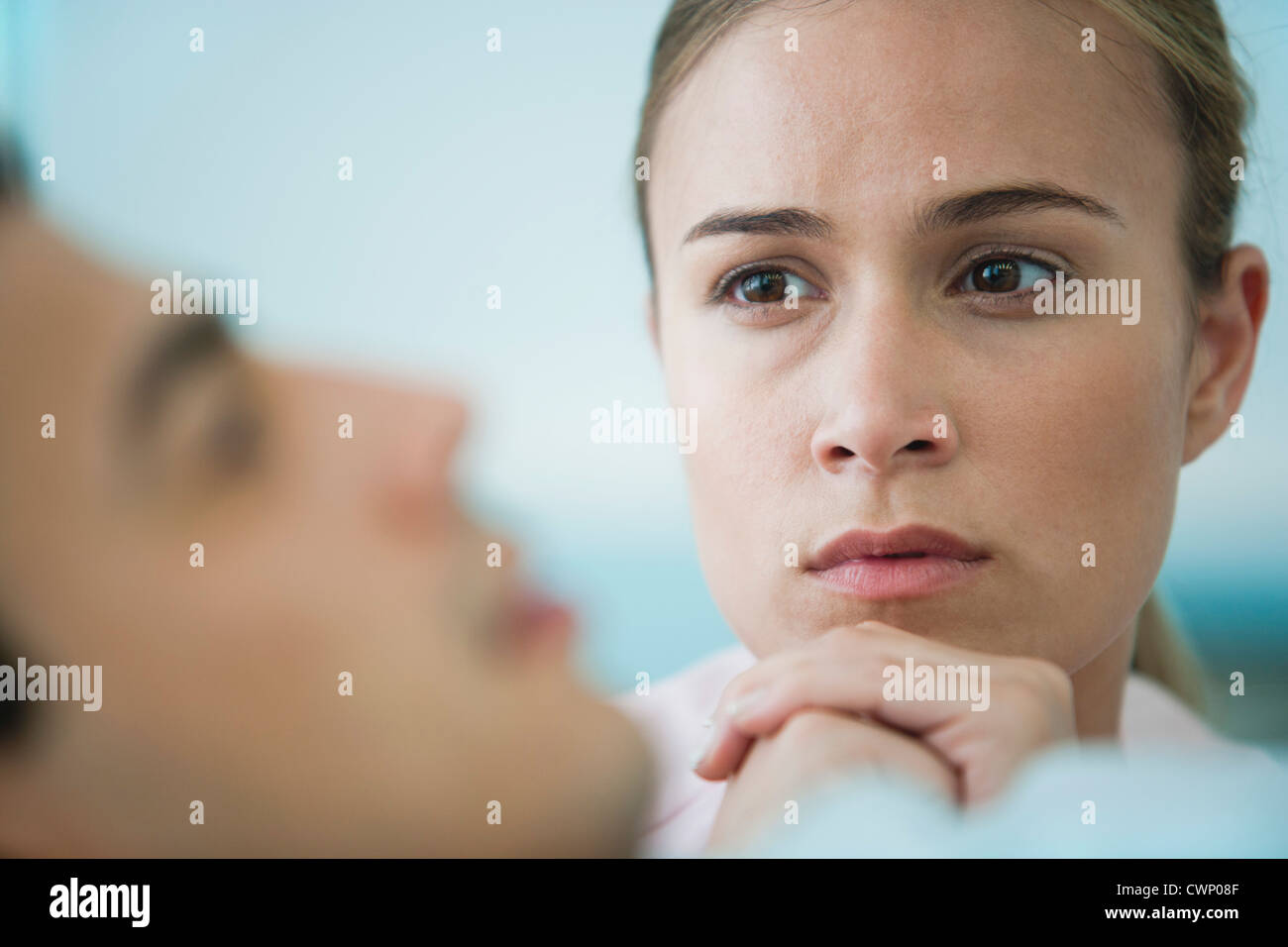 Worried woman looking at sick man in foreground Stock Photo - Alamy