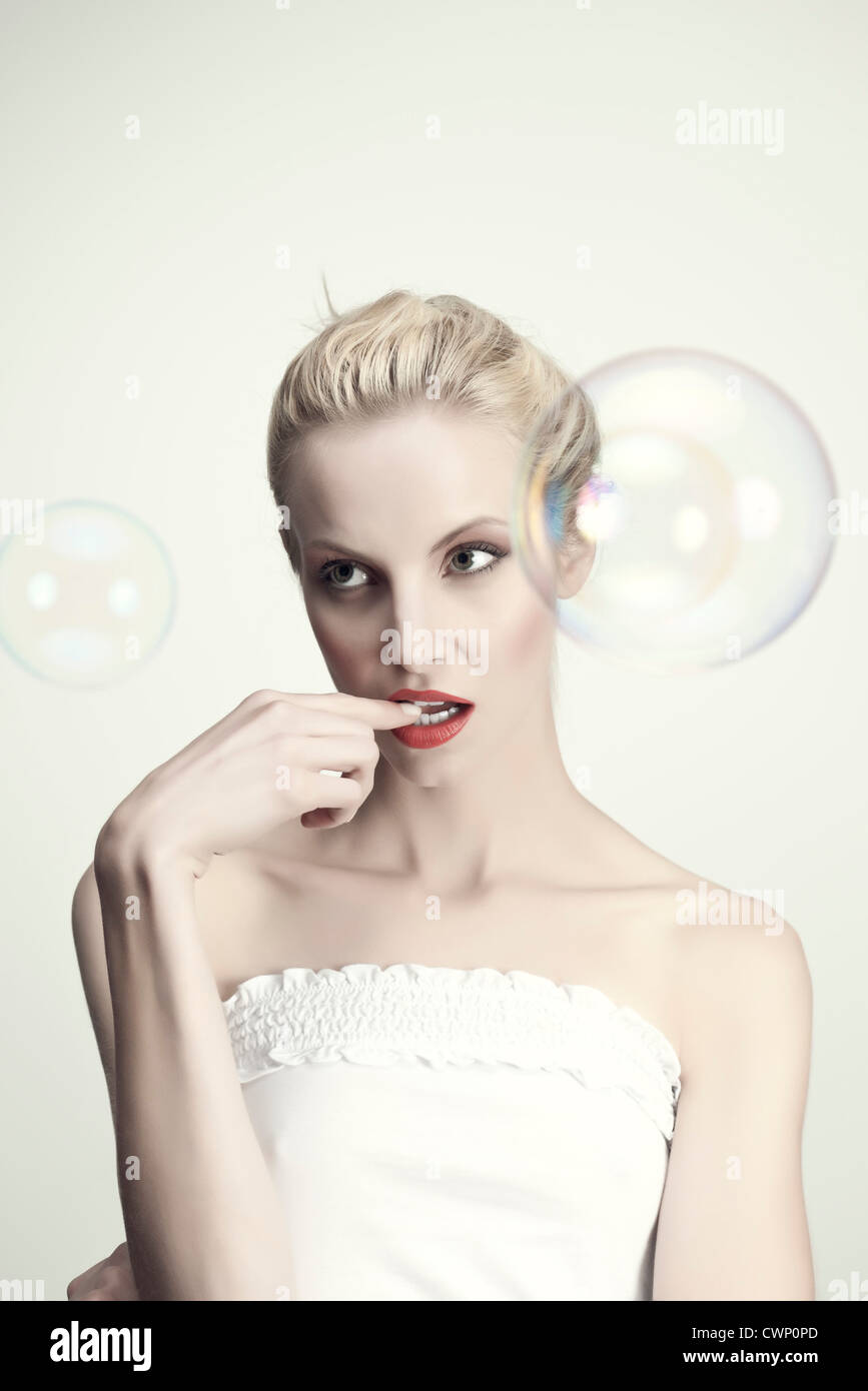 Young woman biting finger, portrait Stock Photo - Alamy