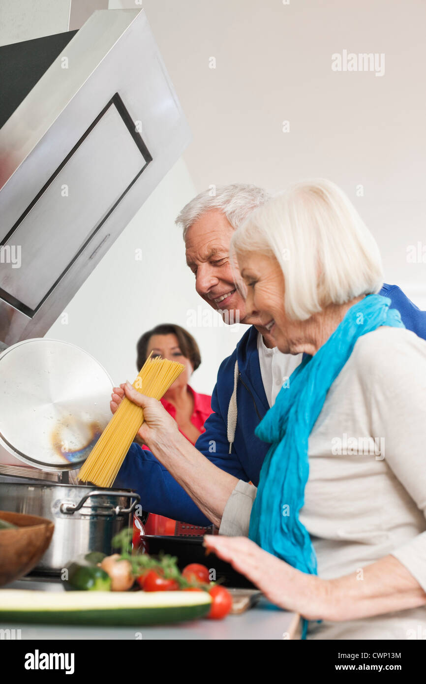 Germany, Leipzig, Man and women cooking food, smiling Stock Photo - Alamy