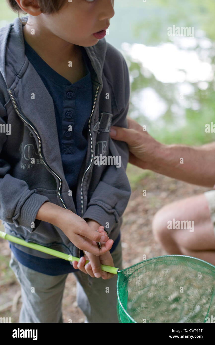 Boy holding fishing net, mid section Stock Photo - Alamy