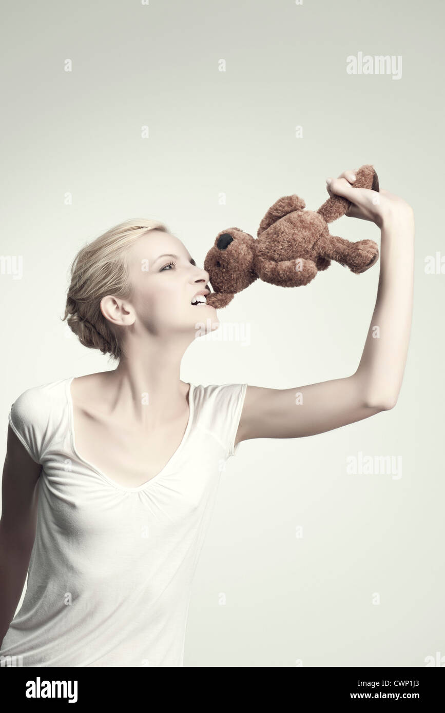 Young woman biting teddy bear, portrait Stock Photo - Alamy