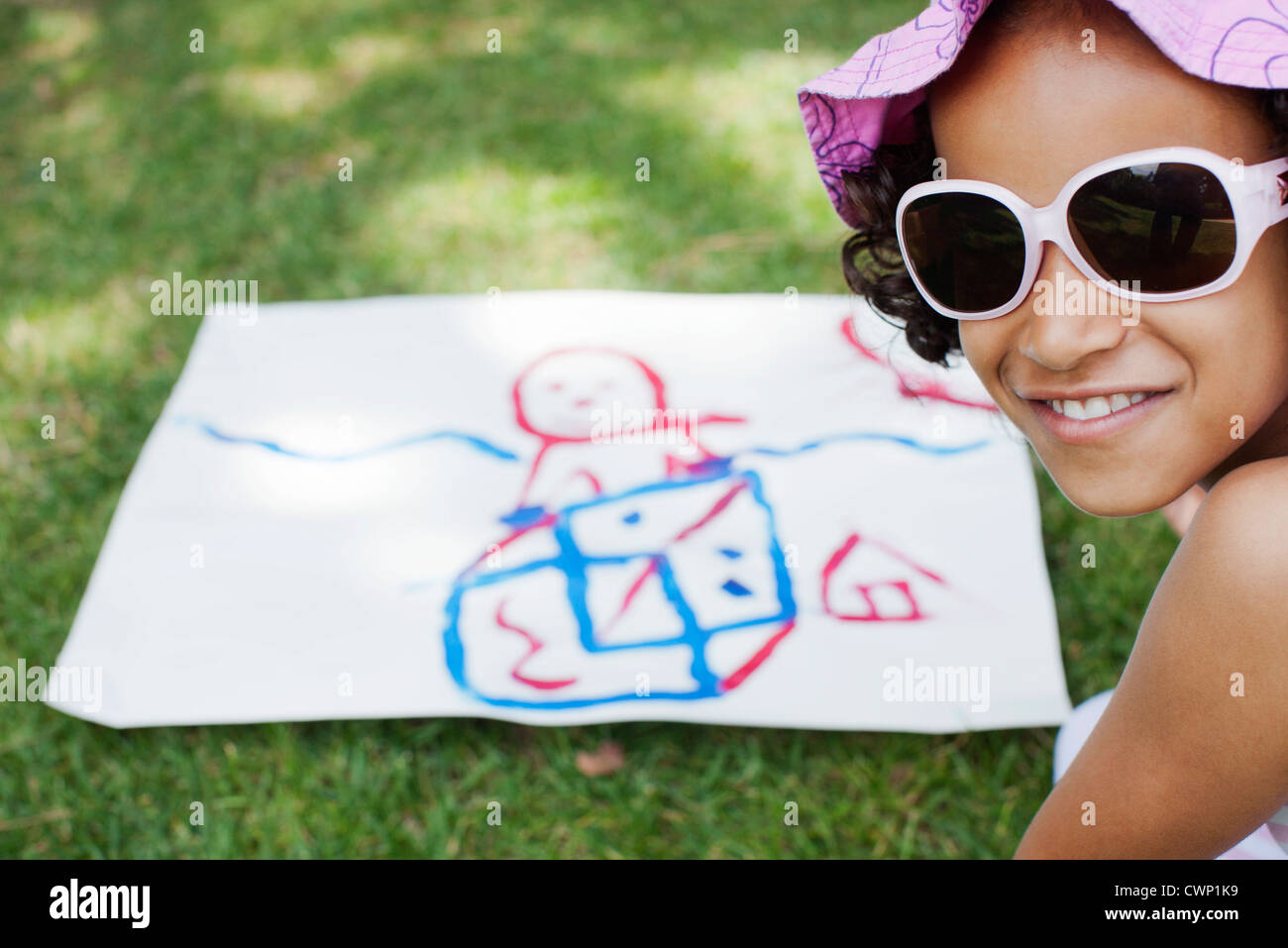 Girl with drawing on grass Stock Photo - Alamy