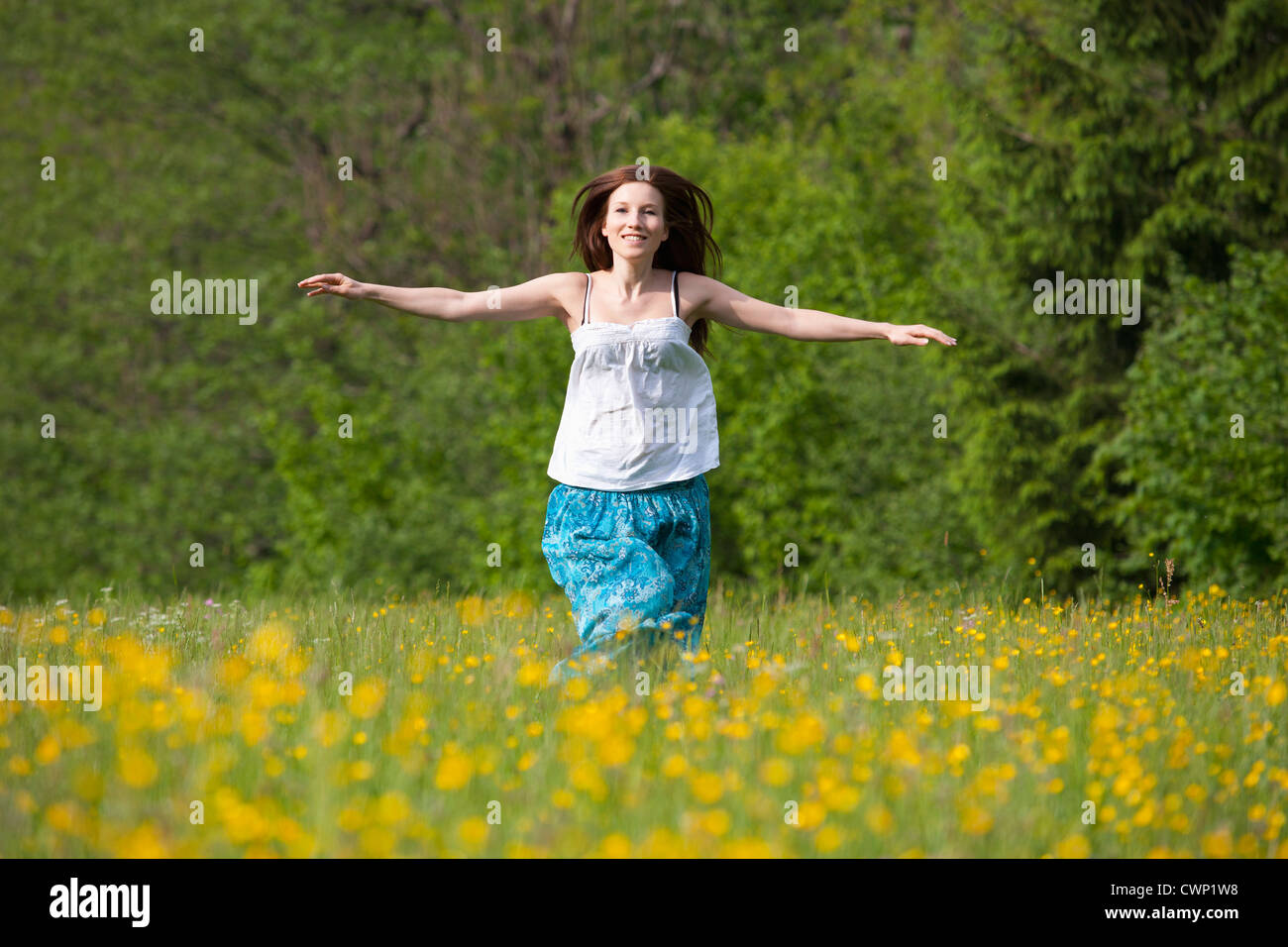 Austria, Young woman running in field of flowers Stock Photo - Alamy